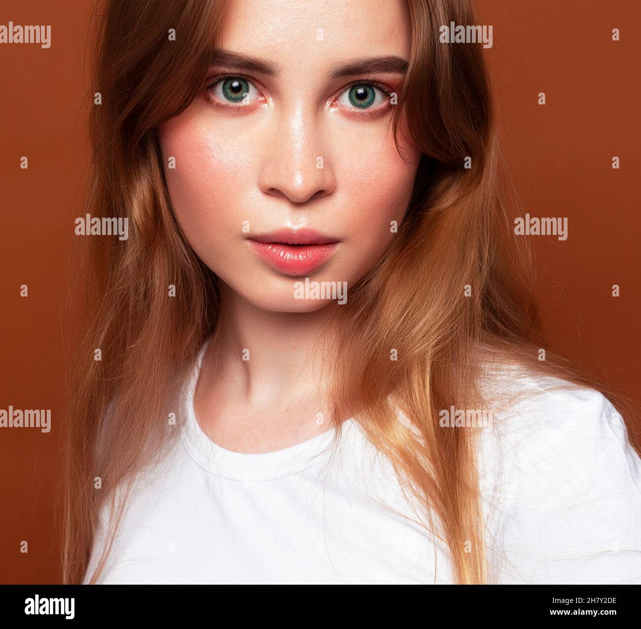 young pretty girl with blond hair posing cheerful on brown background, lifestyle people concept ...