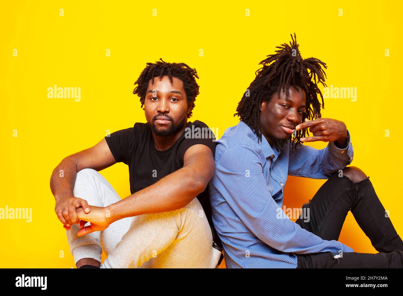 two african american guys posing cheerful together on yellow background, lifestyle people ...