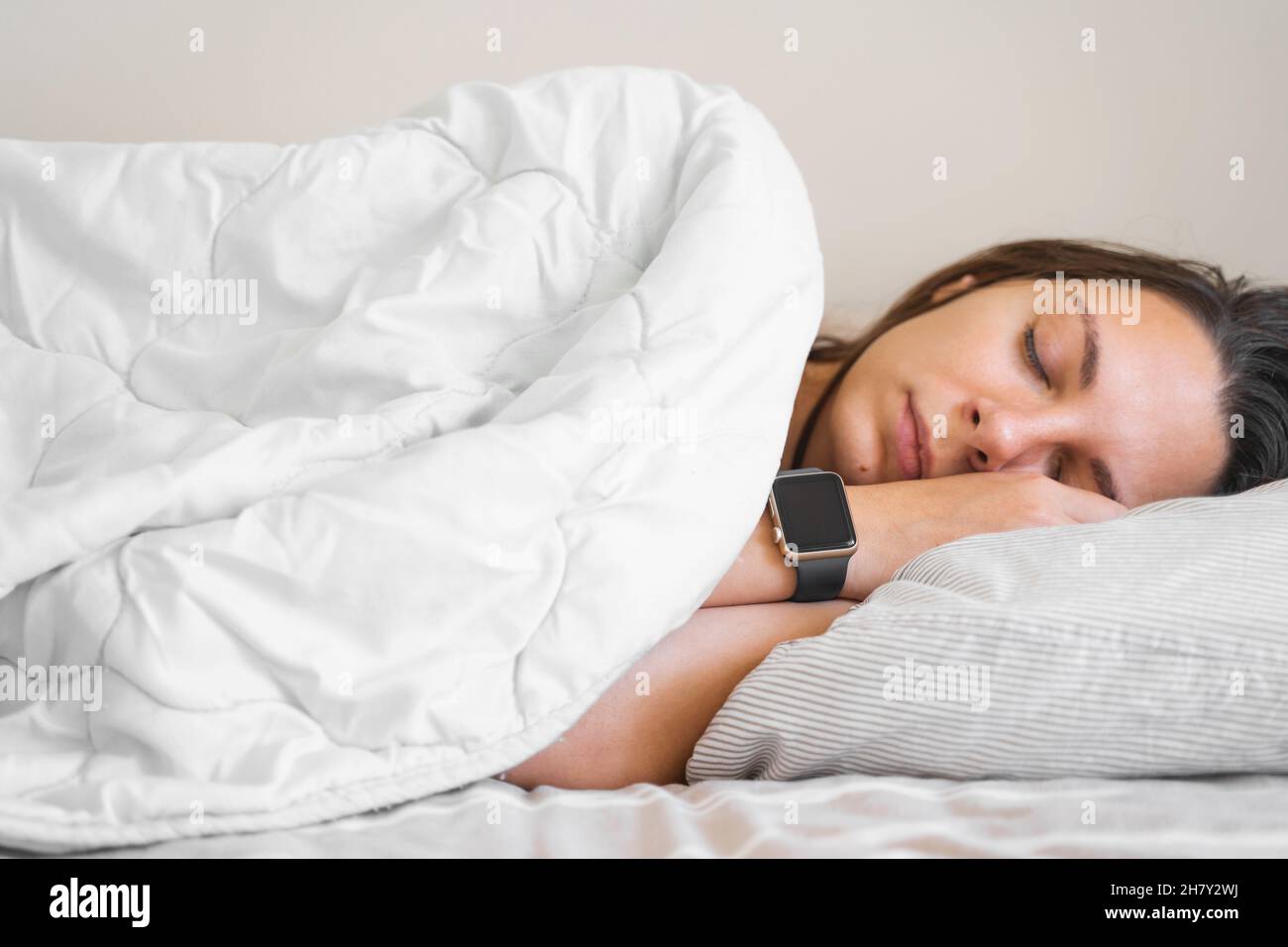 Young woman goes to sleep Phone addiction, insomnia. try to fall asleep ...