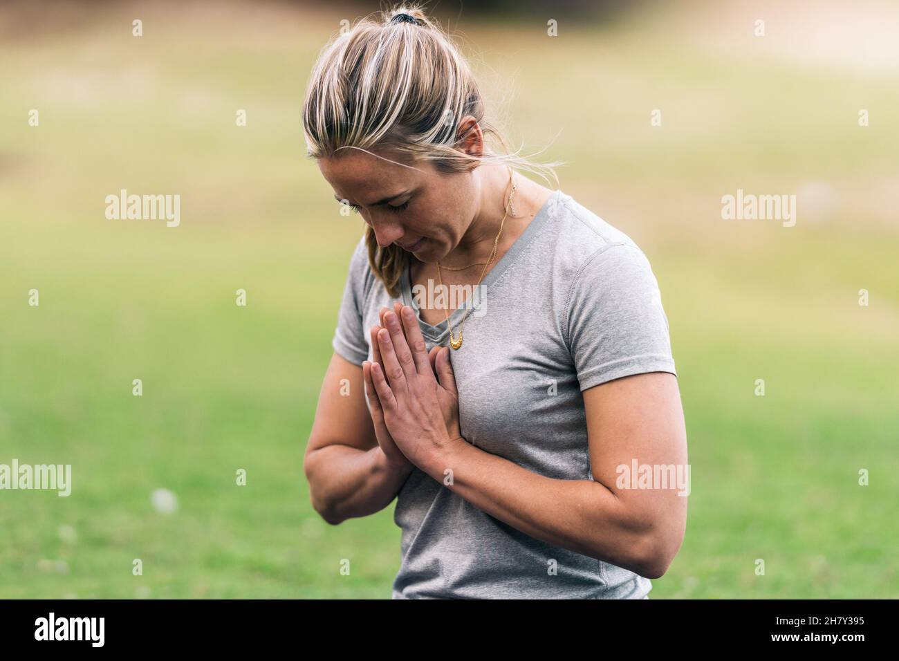 Woman with folded hands in prayer gesture Stock Photo - Alamy