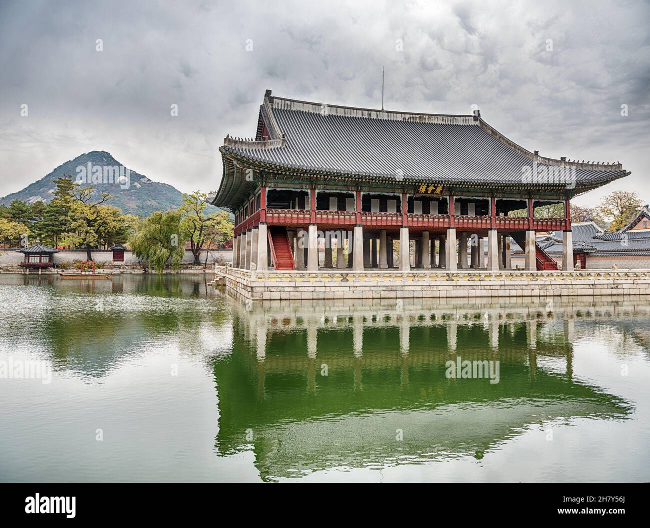 The Gyeonghoeru pavilion is located next to a pool of water in the ...