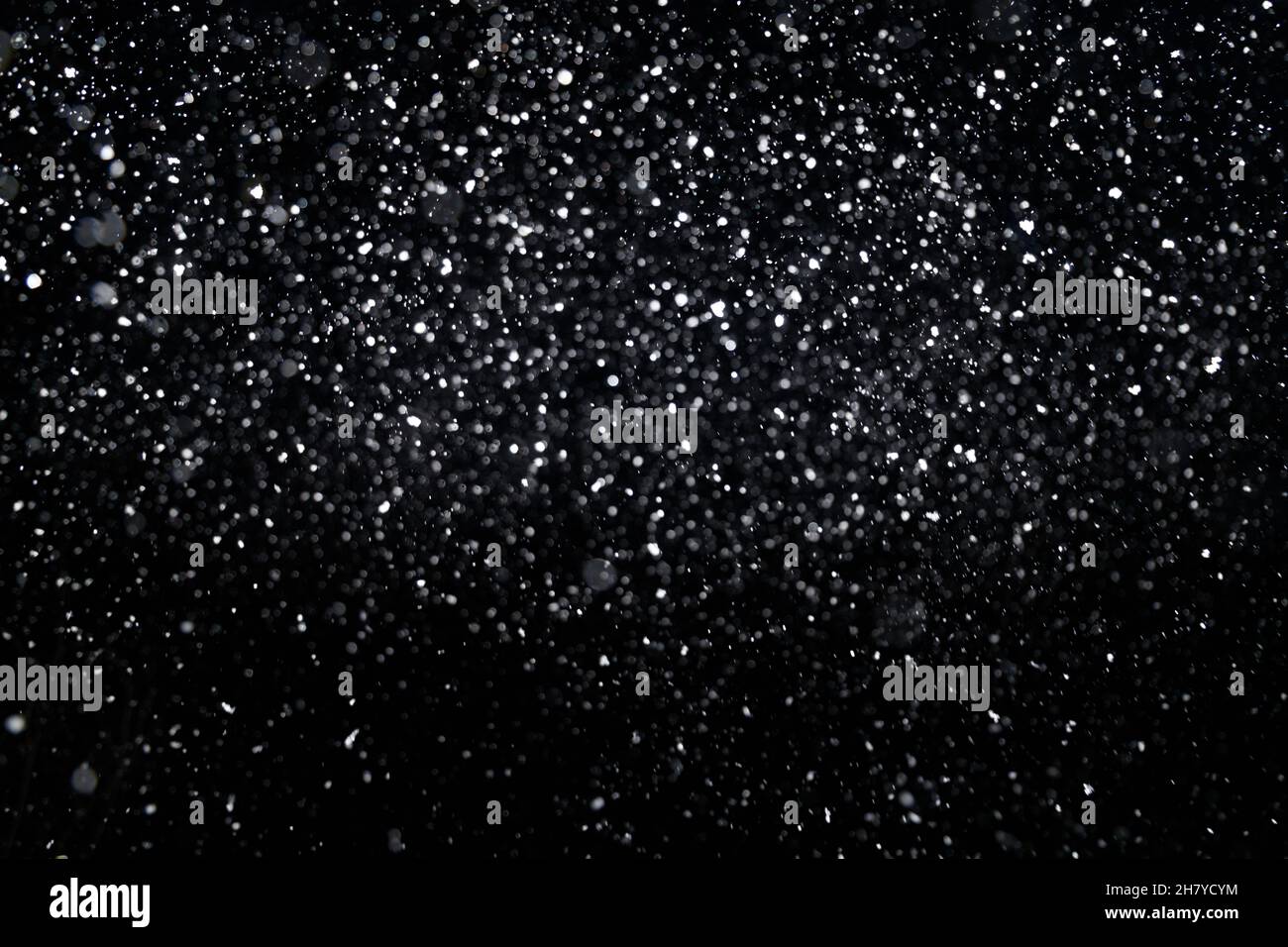 Many snowflakes in blur on black background. Snowfall layer for winter ...
