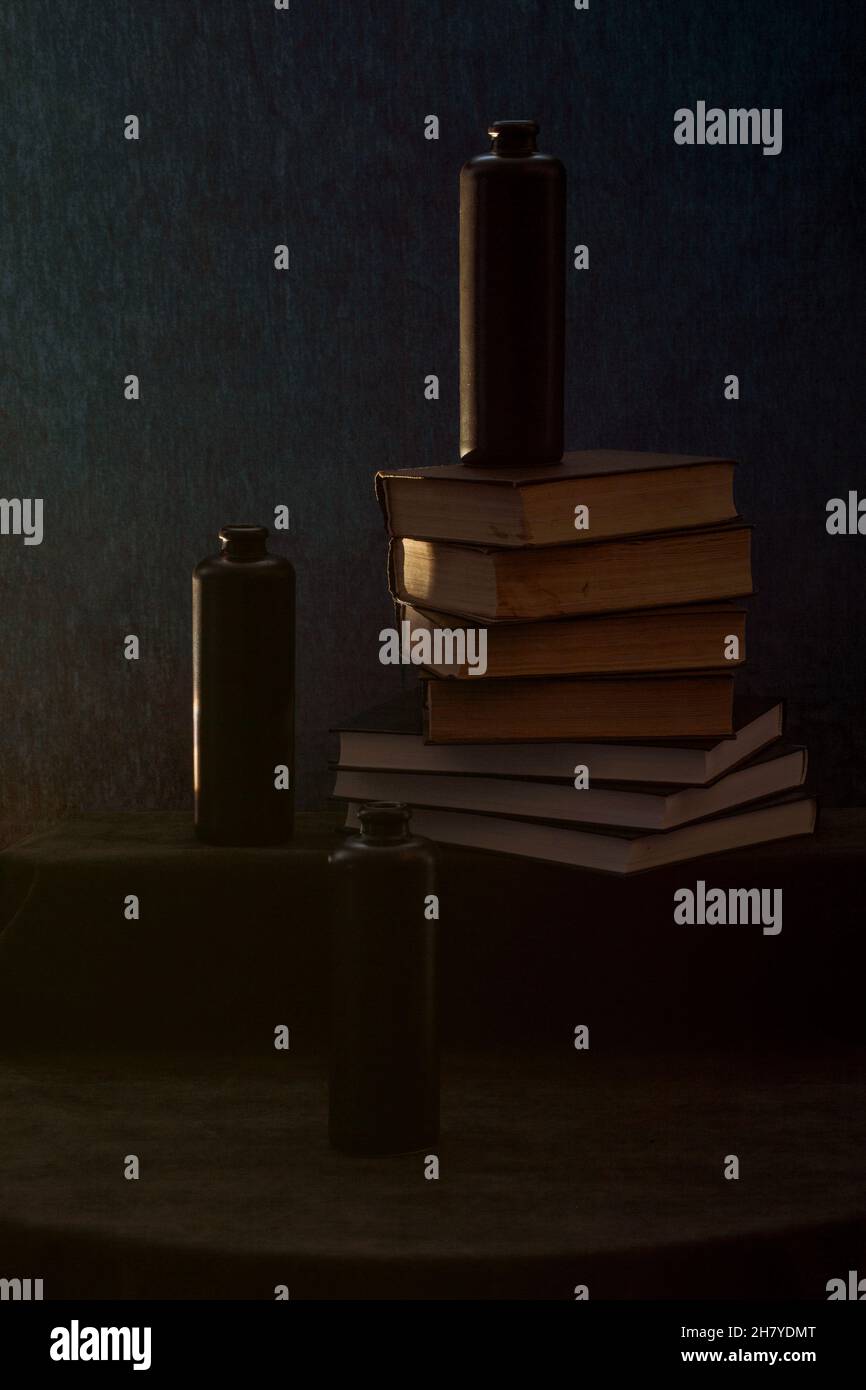 Still life with books and black bottles Stock Photo - Alamy