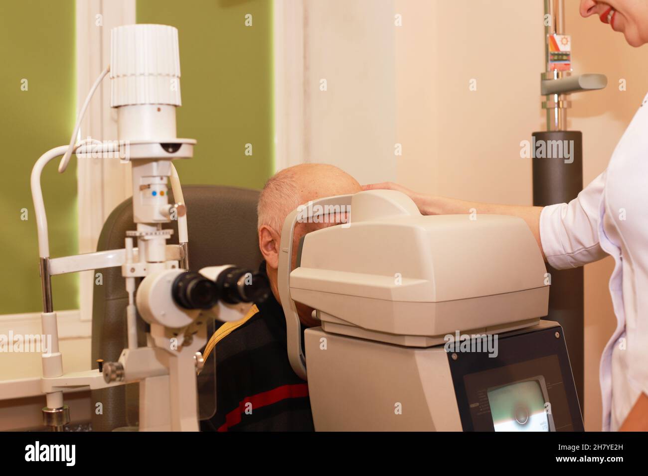 An older man taking an eye test examination at an opticians clinic ...
