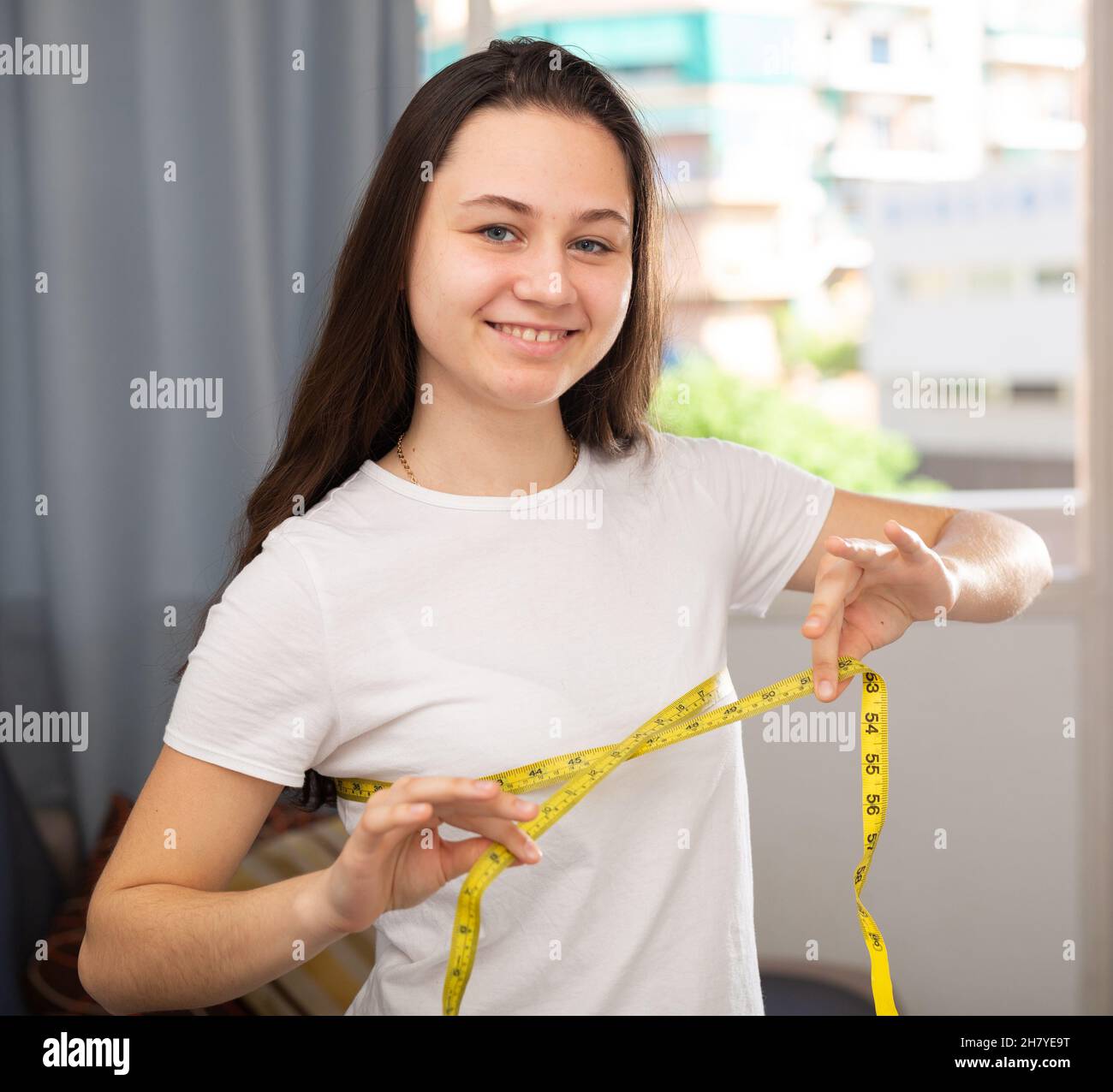 Portrait of woman taking measurements of body Stock Photo - Alamy