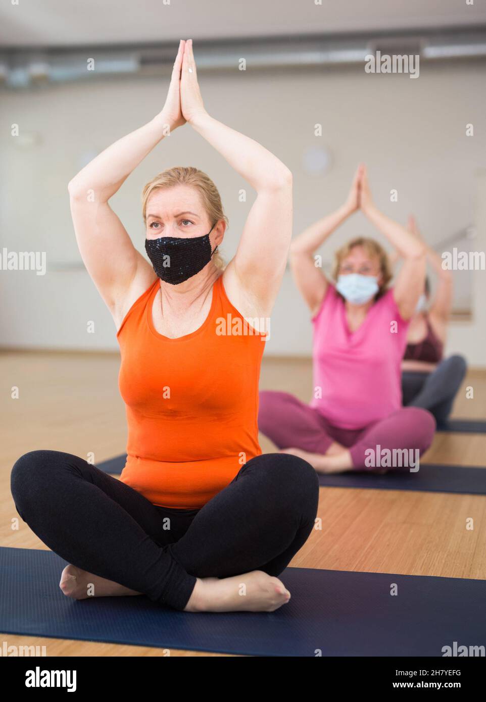 Ladies in masks are sitting in a lotus pose Stock Photo - Alamy