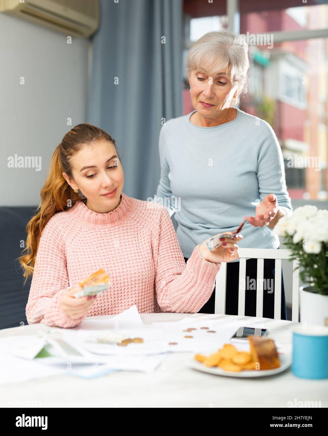 Daughter giving money to mother Stock Photo - Alamy