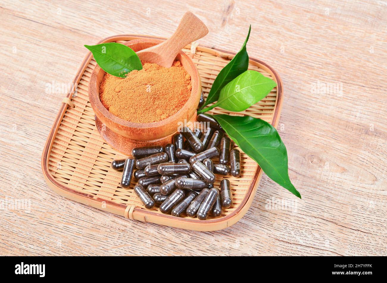 Yellow herbal medicine powder and capsules with green organic herb ...