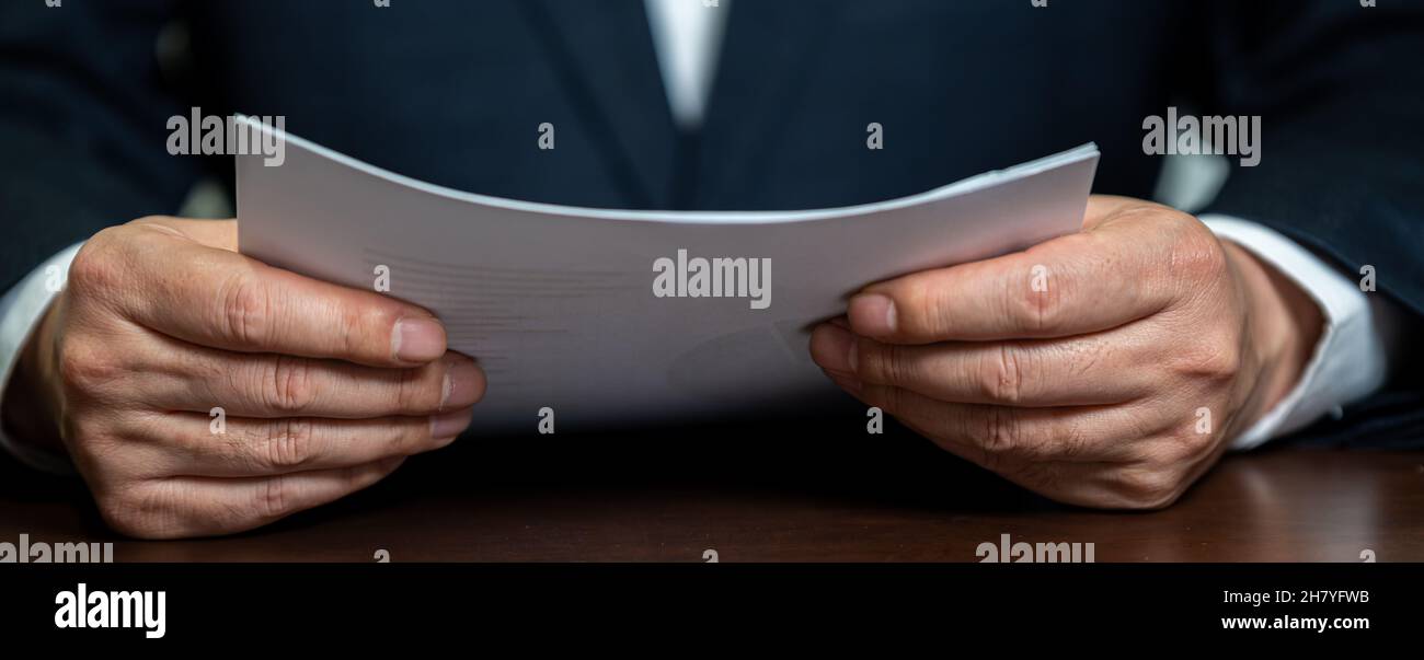 A businessman holding a white paper document Stock Photo - Alamy