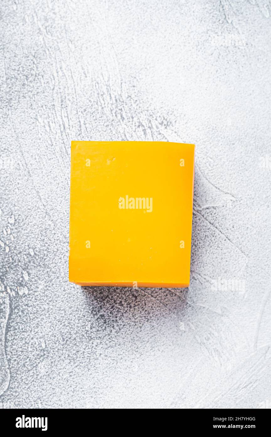 Cheddar Cheese block on a kitchen table. White background. Top view ...