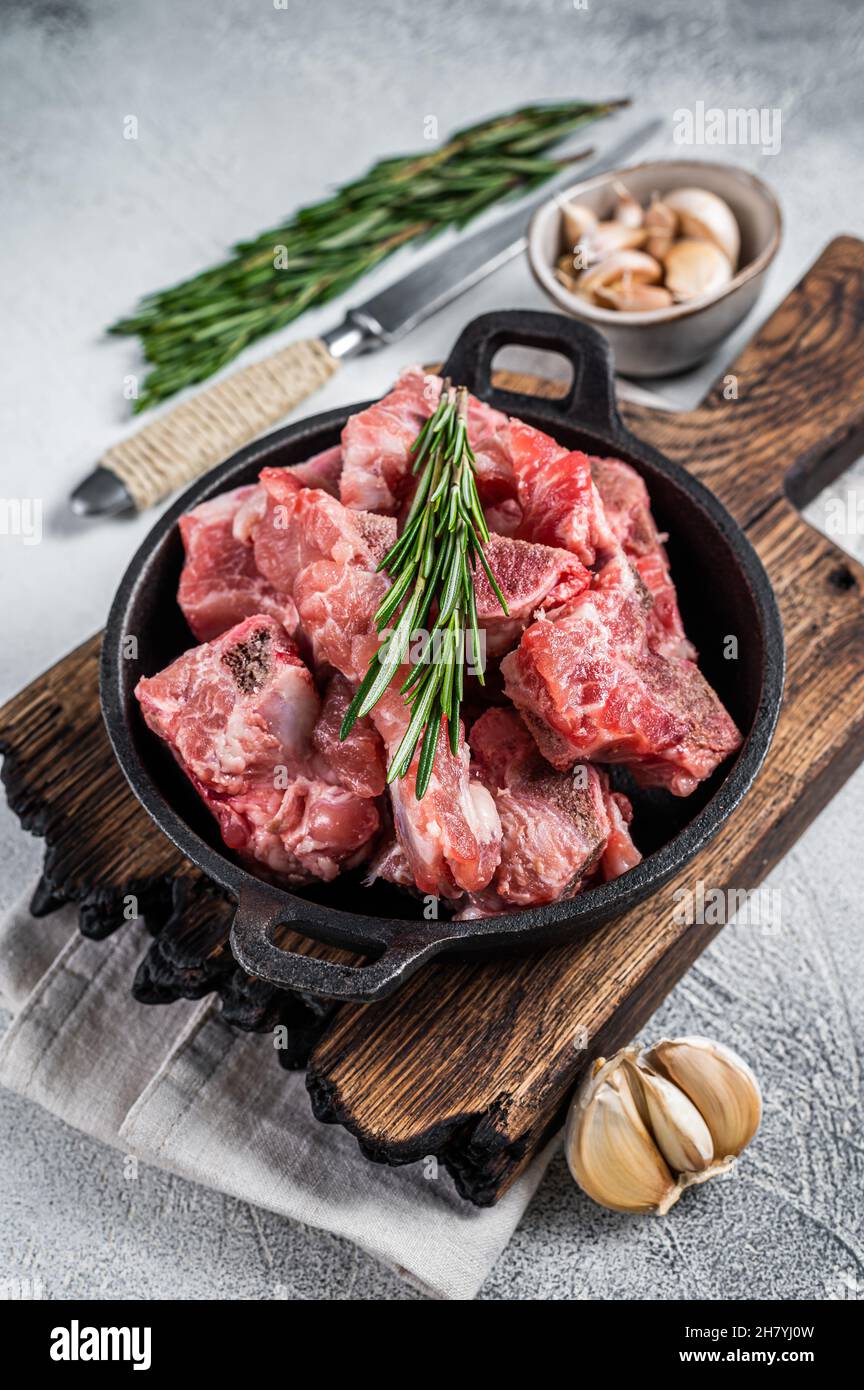 Raw diced meat cubes with bone in a pan. White background. Top View ...