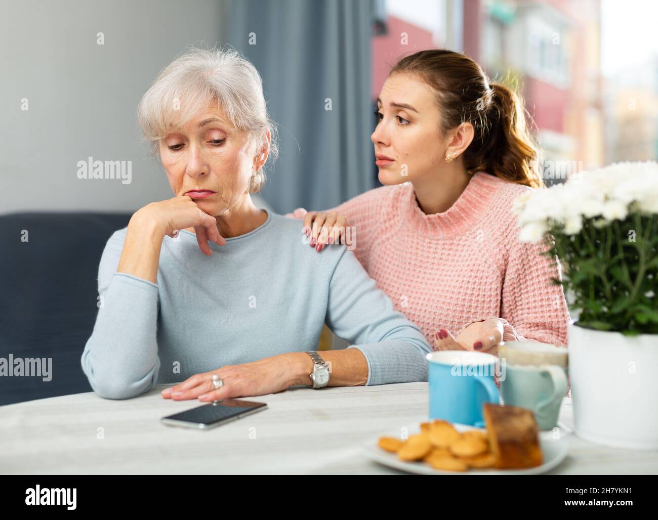 Young woman encouraging her upset mother Stock Photo - Alamy