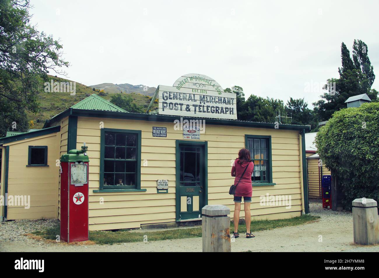 A tourist stamding infront of the old General Merchant, Post ...