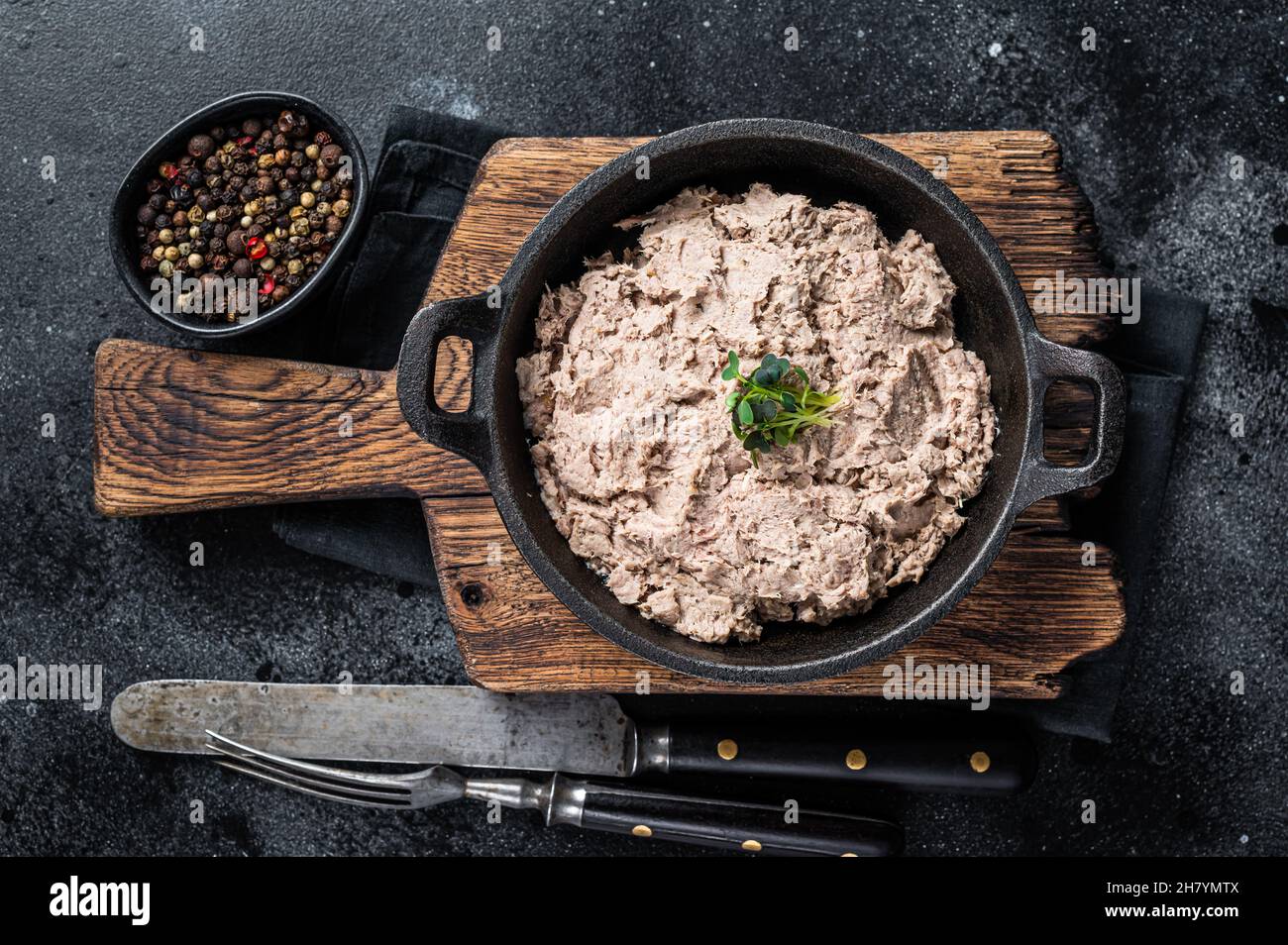 Duck pate Rillettes de Canard in a pan with greens. Black background ...