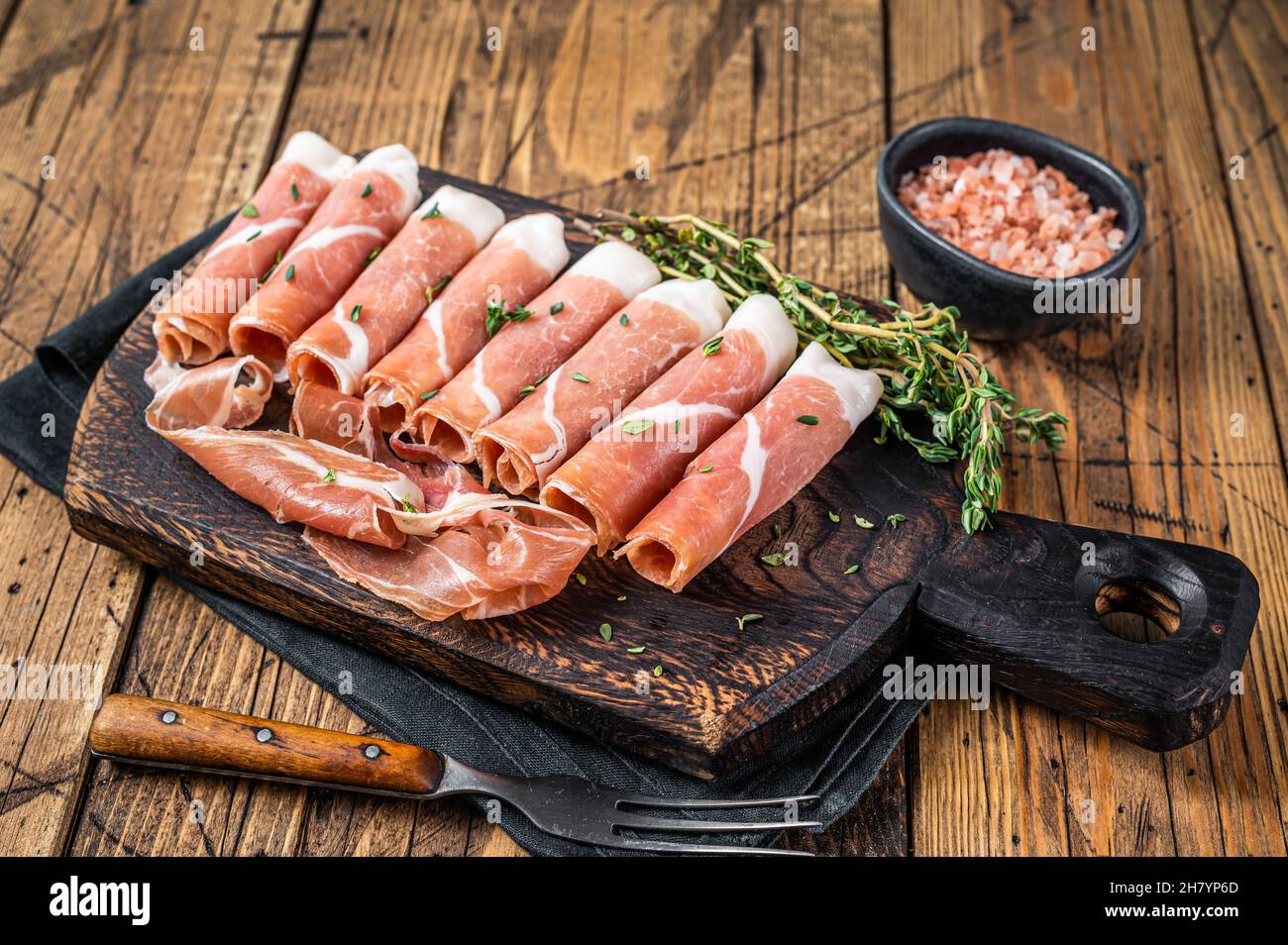Prosciutto crudo Dry cured parma ham on a wooden cutting board with ...