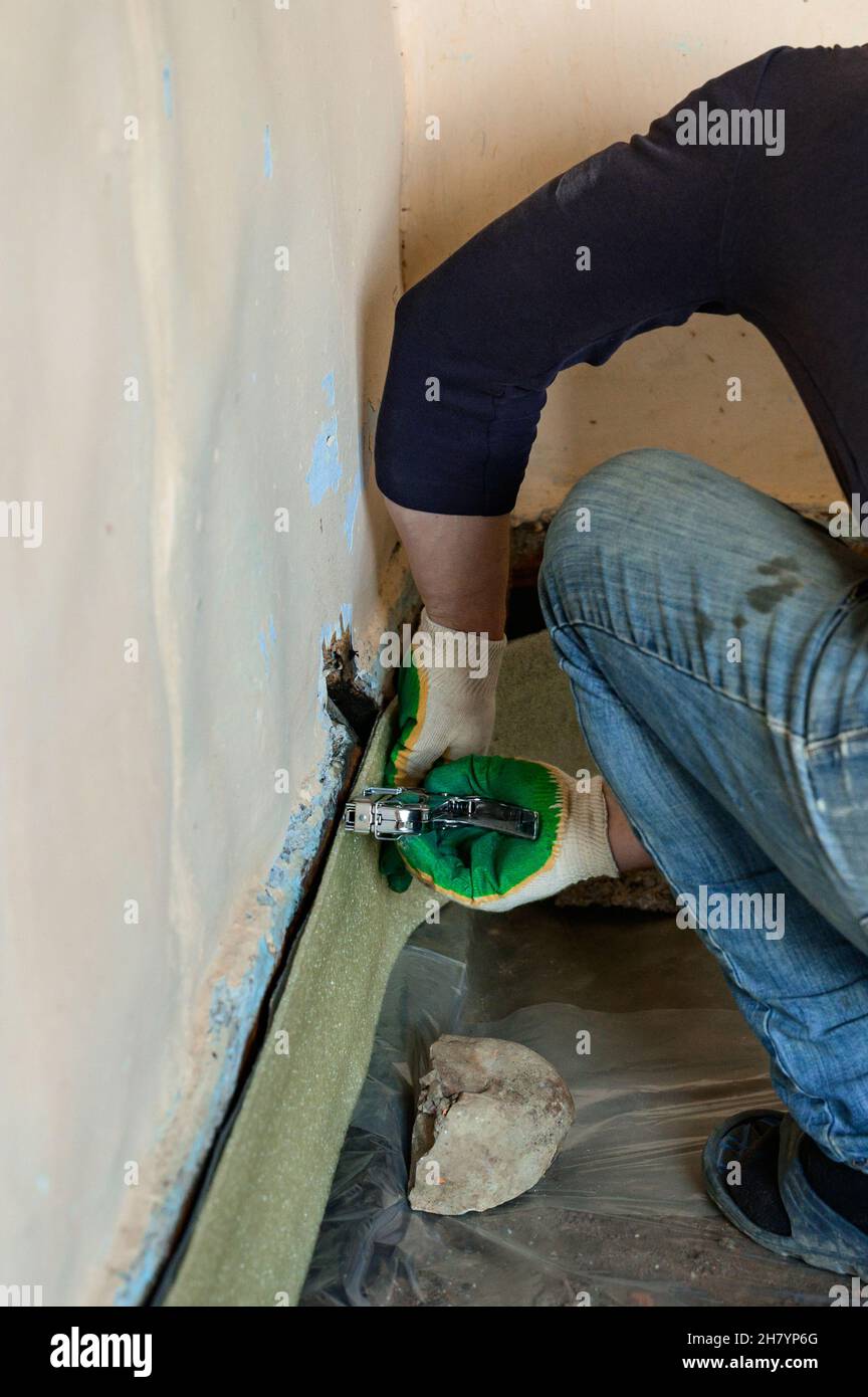 Installing damping tape with a stapler, close up of repair work in the ...