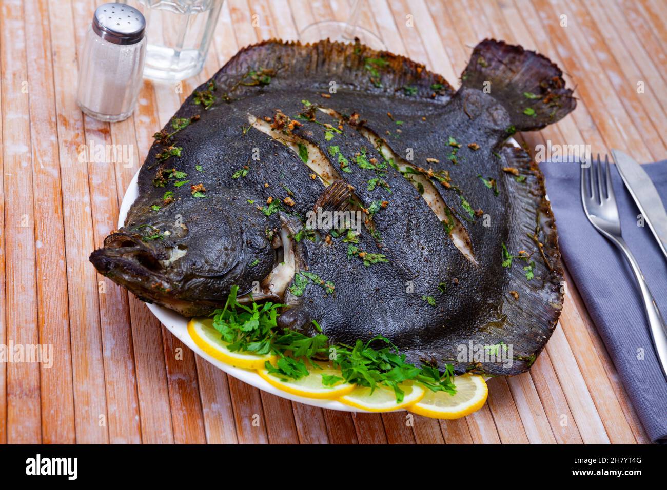 Baked brill fish with lemon and greens Stock Photo - Alamy