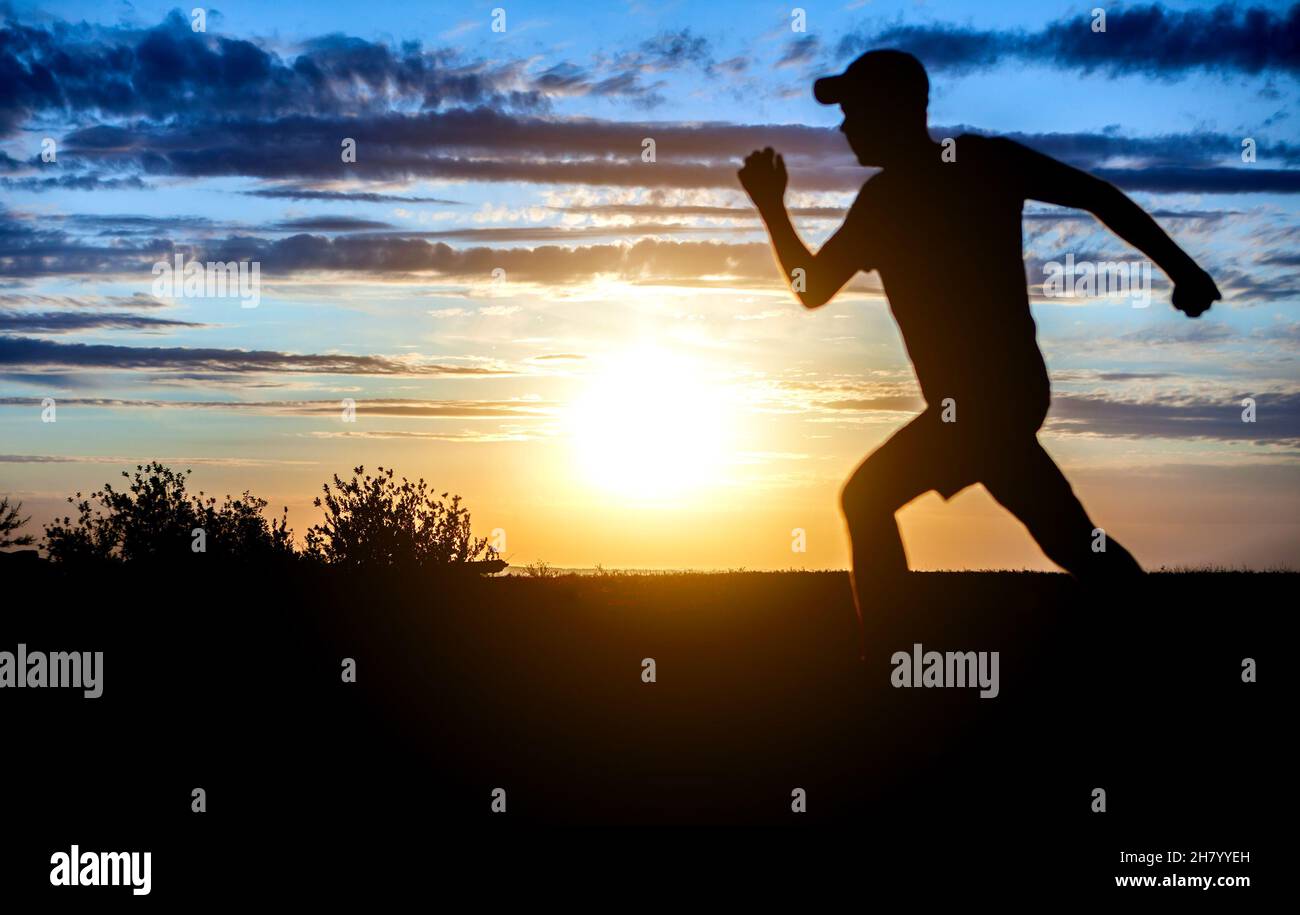Silhouette of the Man running on the Sunset Background Stock Photo - Alamy