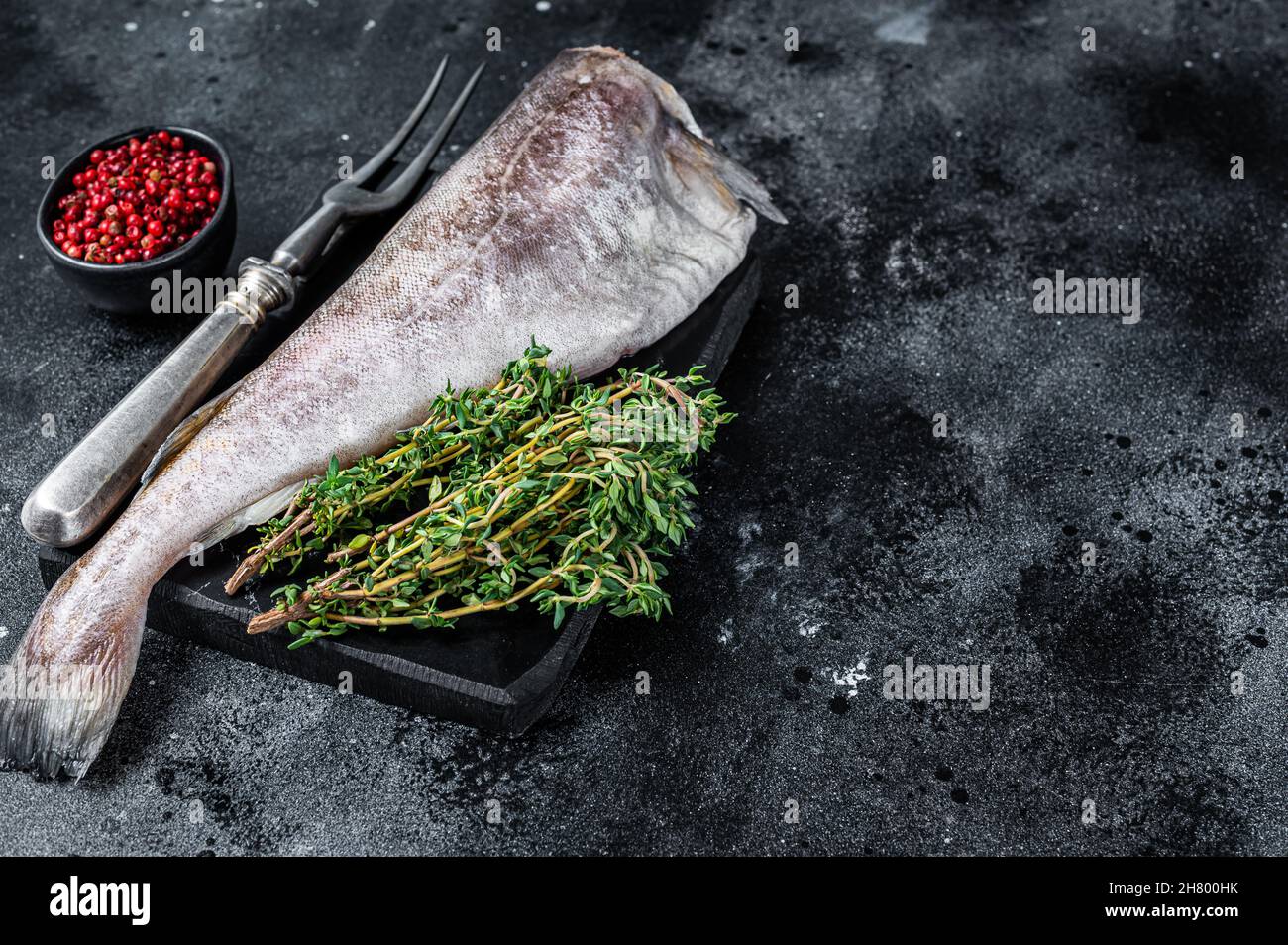 Uncooked Raw cod whole fish on marble board with thyme. Black ...