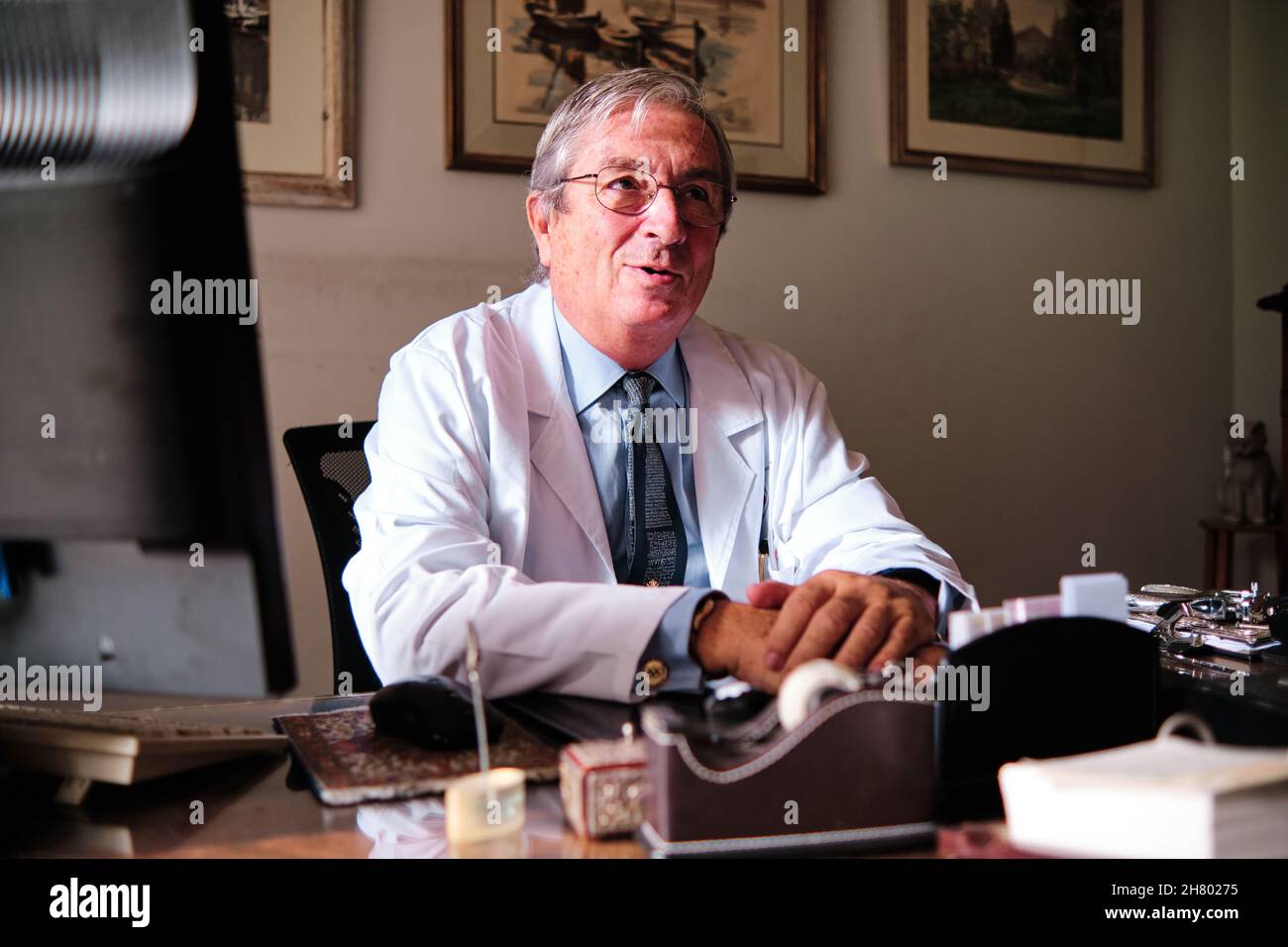 old doctor at his desk consulting Stock Photo - Alamy
