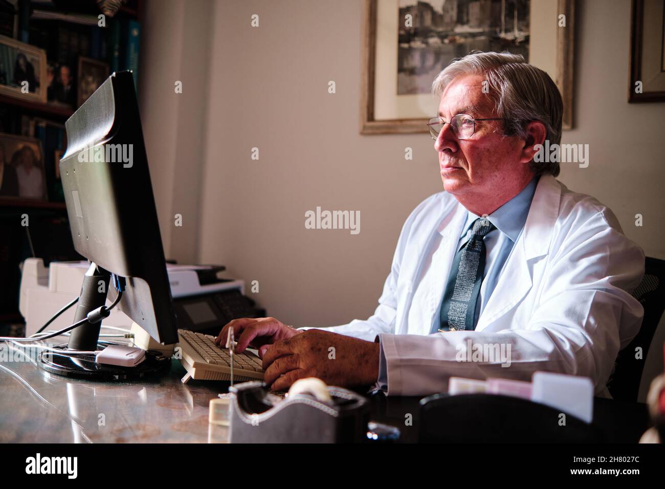 old doctor at his desk consulting Stock Photo - Alamy