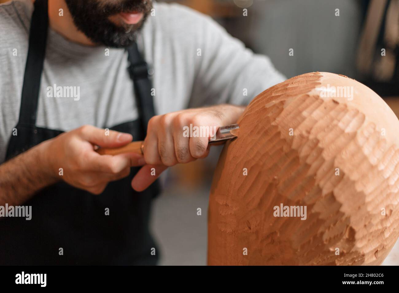 Anonymous carpenter shaping round wooden detail with professional ...