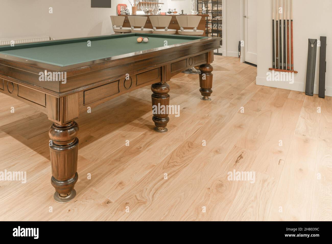 Interior of modern billiard room with pool table under chandeliers near ...