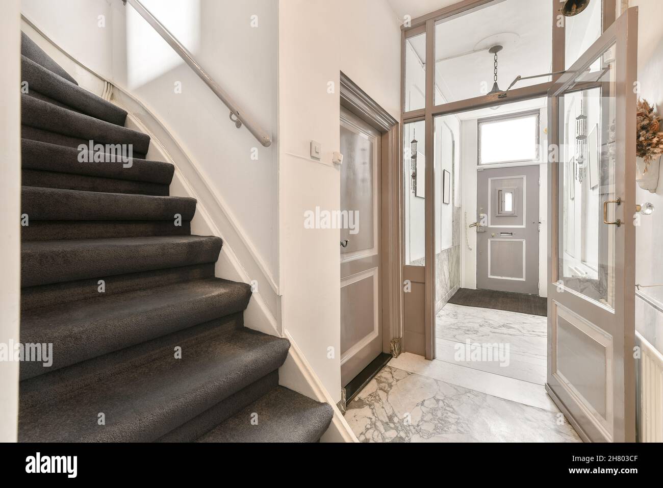 Stairway with gray steps and railing in corridor of contemporary house ...