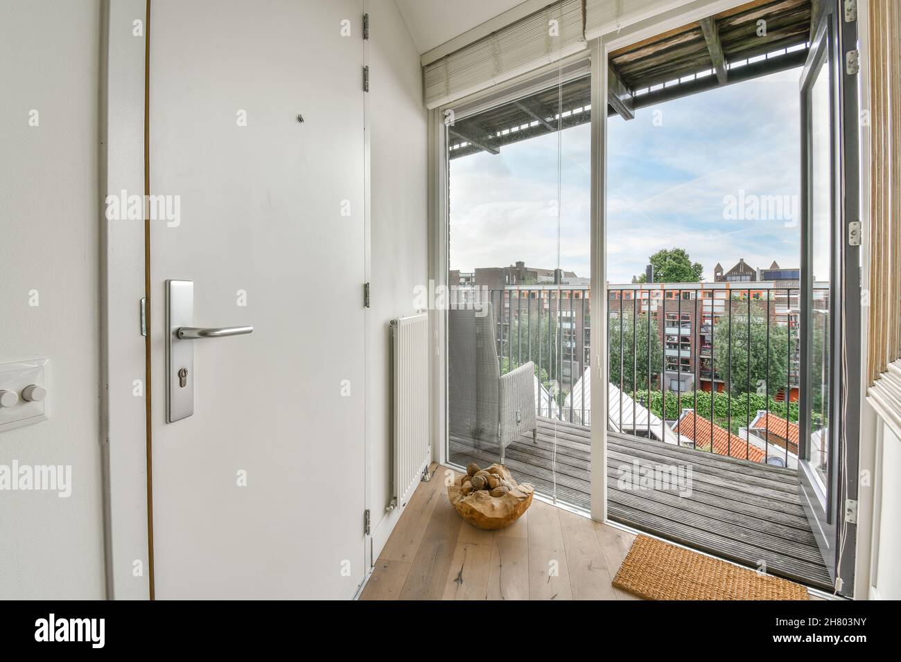Corridor of contemporary apartment with closed door and balcony with ...