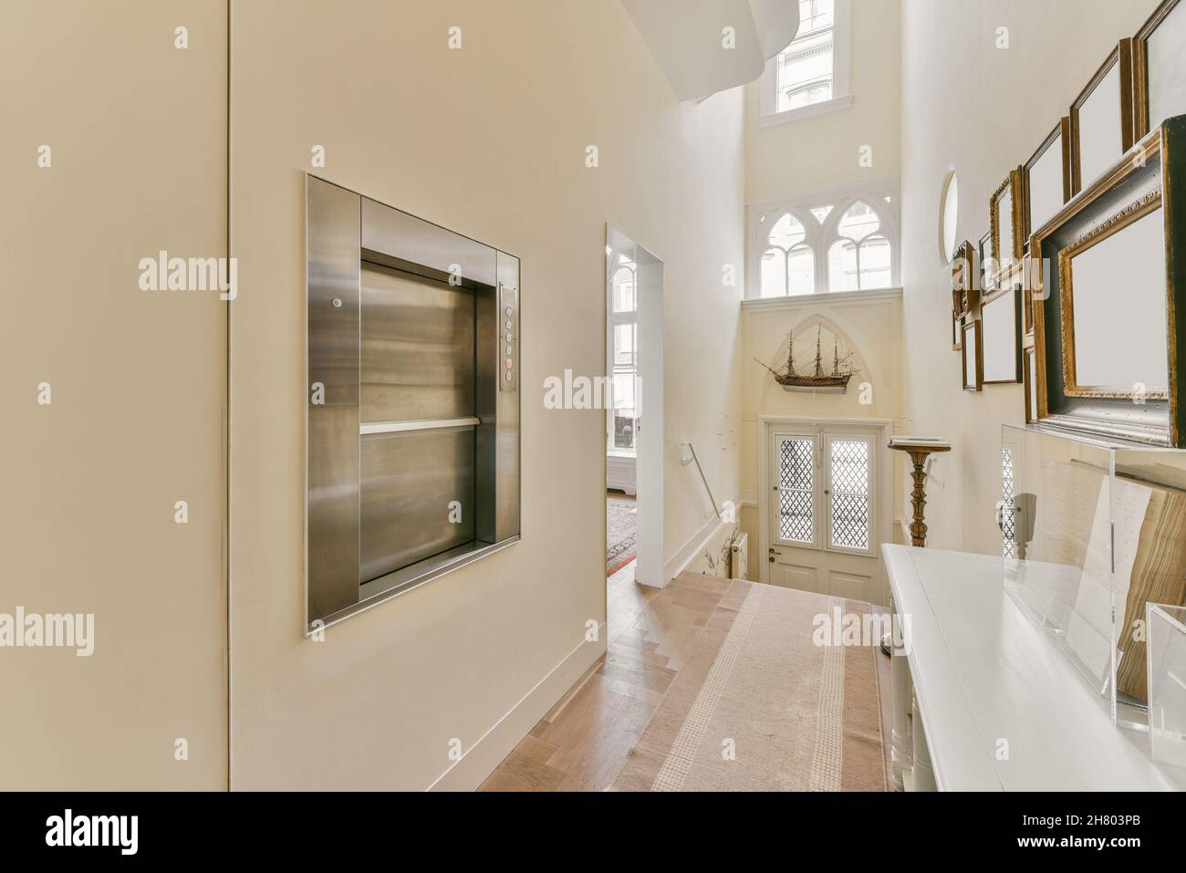 Corridor with collection of empty photo frames hanging on white wall ...