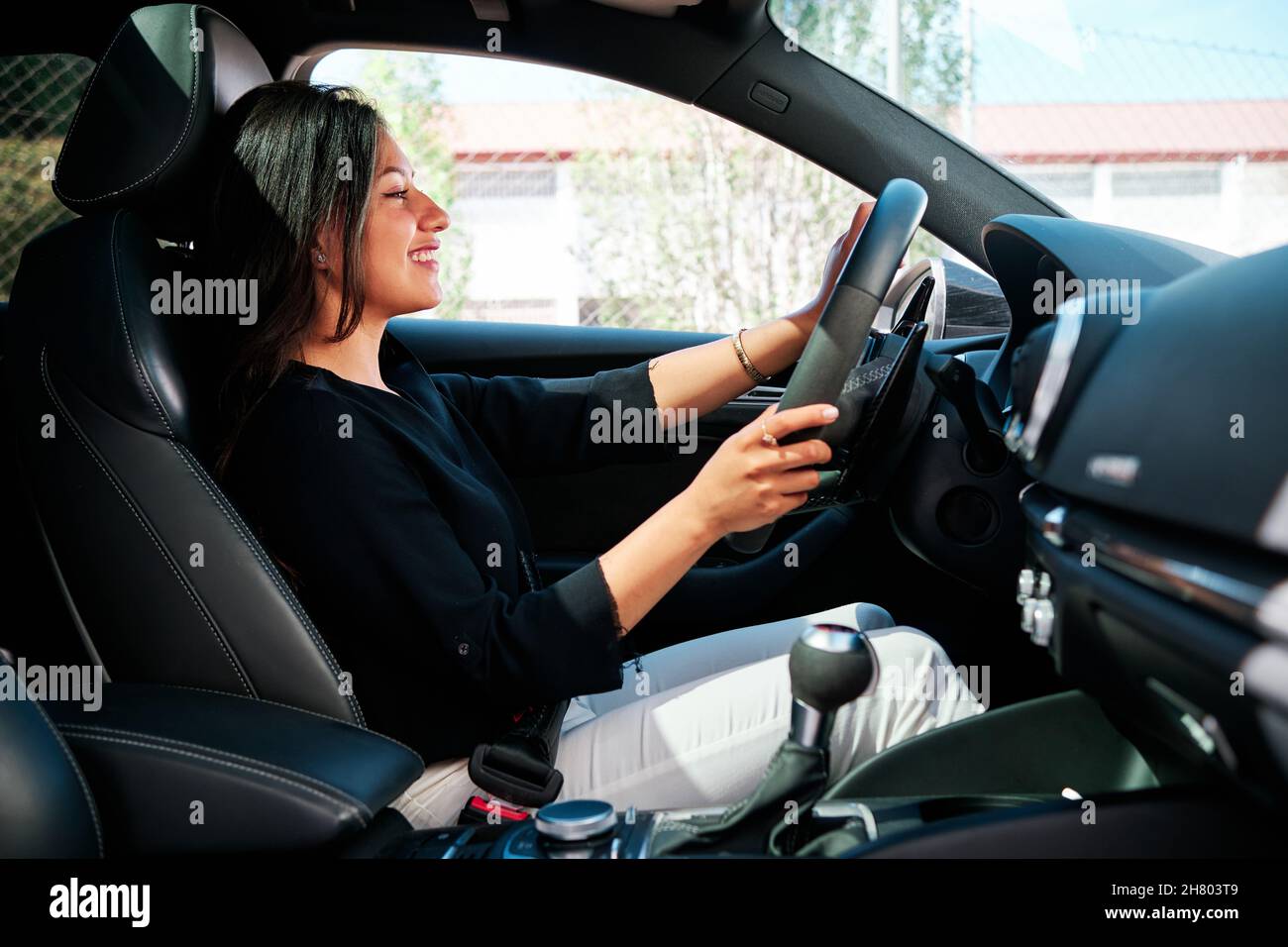 young latin woman driving luxury car Stock Photo - Alamy