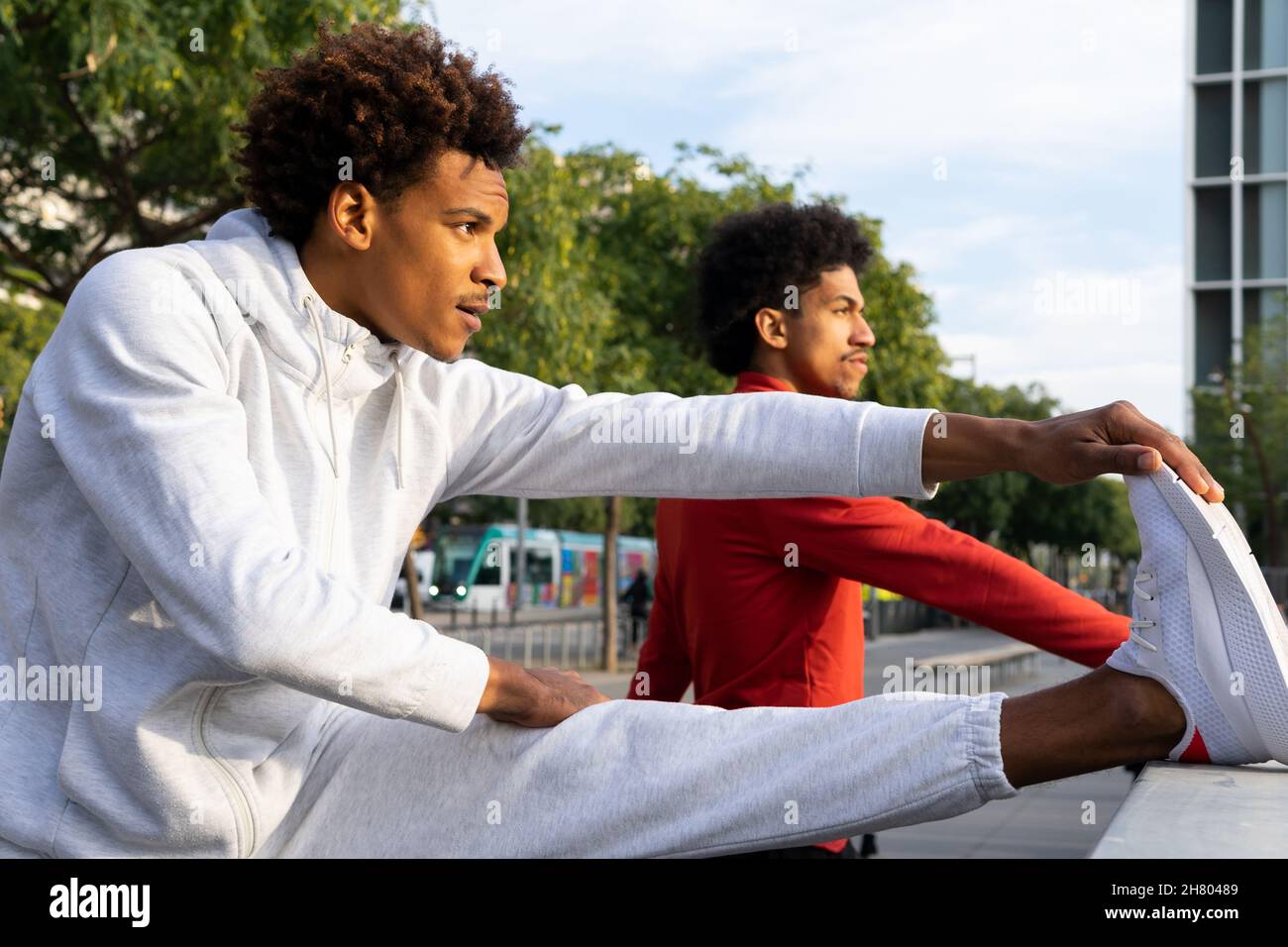 Side view of African American male doing hamstring stretch with leg on ...