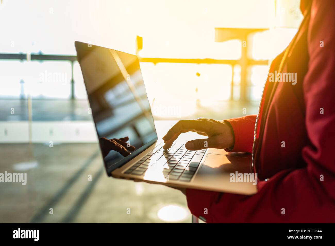 Crop anonymous tourist typing on modern netbook keyboard while sitting ...