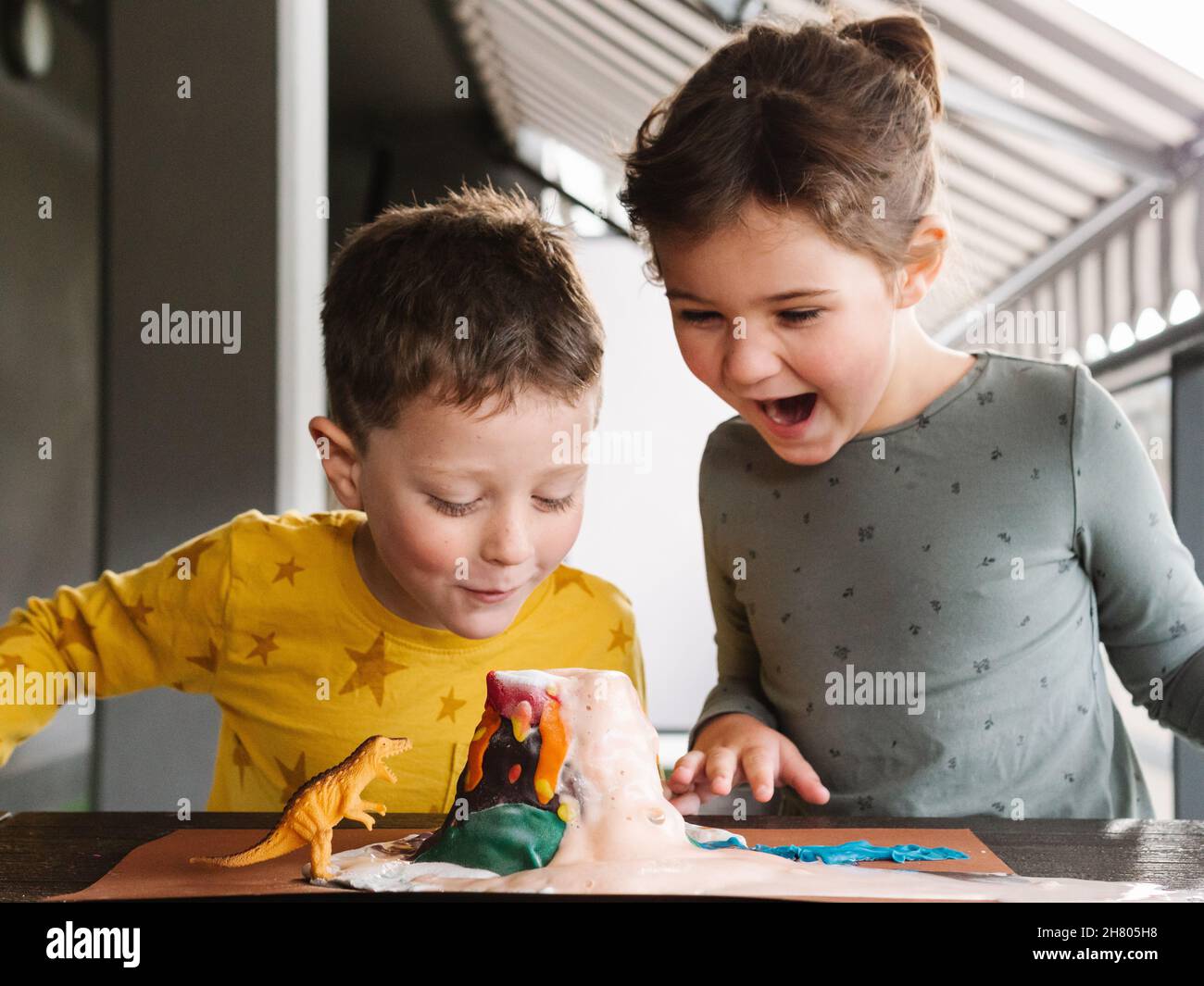 Adorable excited little boy and girl in casual clothes looking at ...