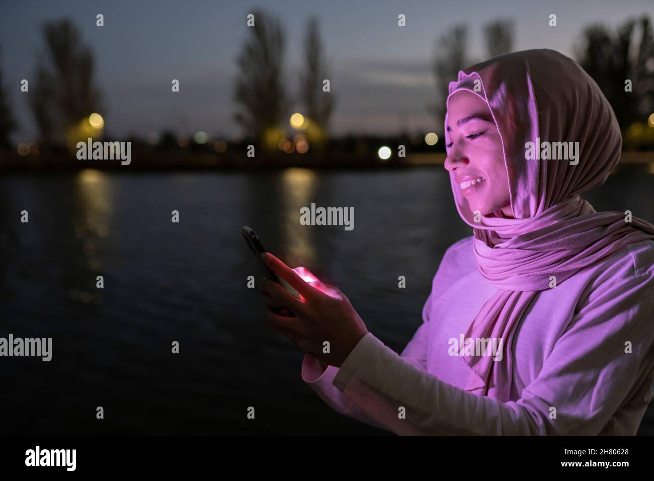 Delighted Arab female in hijab lightened by bright purple color from ...