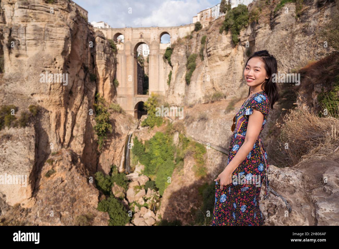 Full body of positive Asian female traveler looking at camera while ...