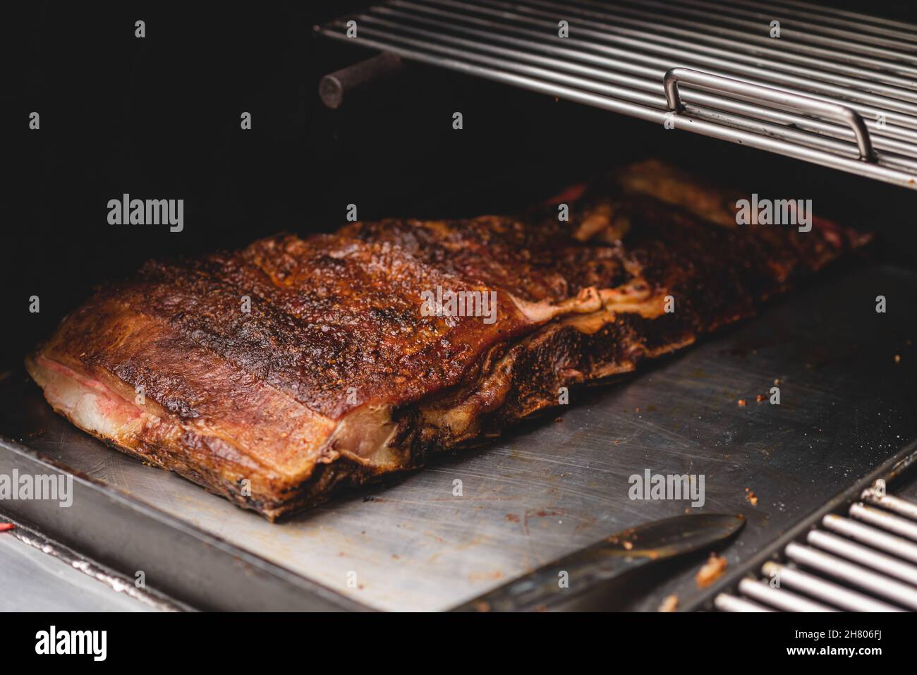 Delicious grilled pork ribs with crust placed on metal rack in modern ...