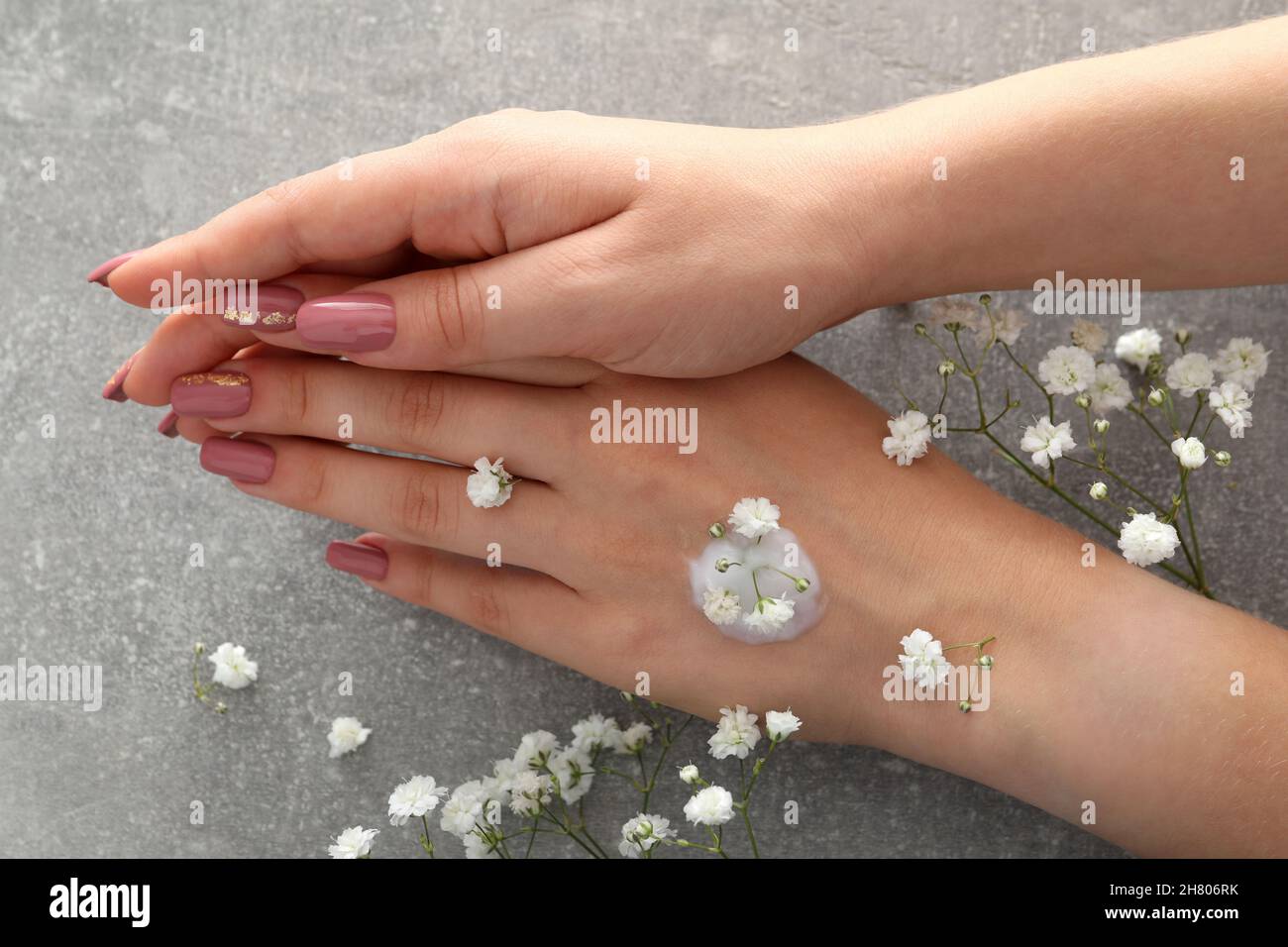 Beautiful female hands with cream on gray textured background Stock ...