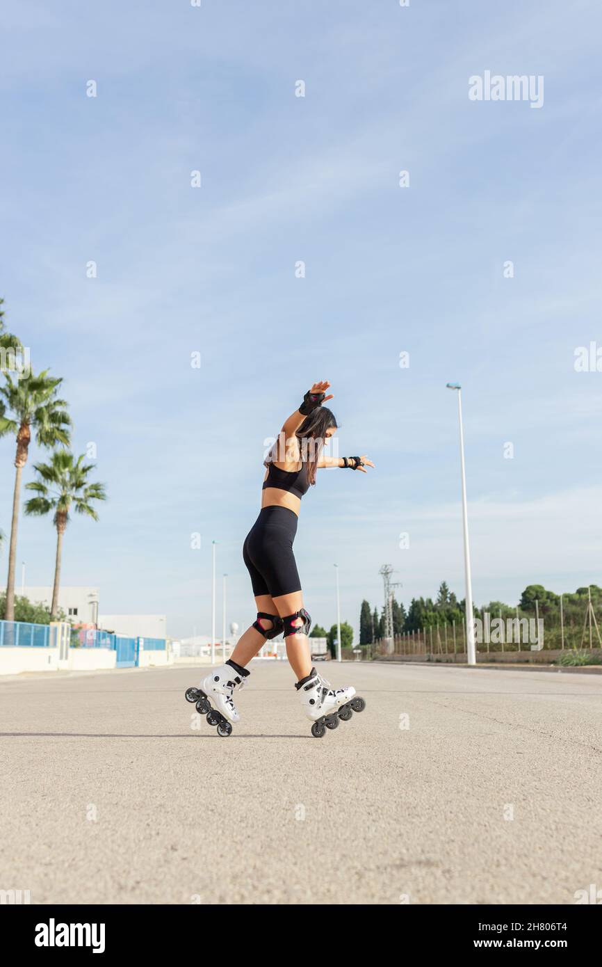 From below full body side view of active fit female outstretching arms ...