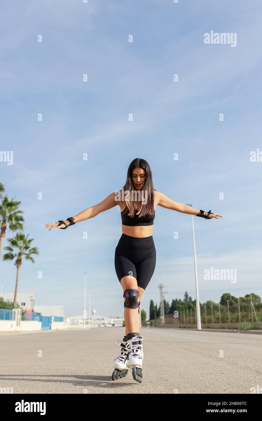 From below full body of active fit female outstretching arms while ...