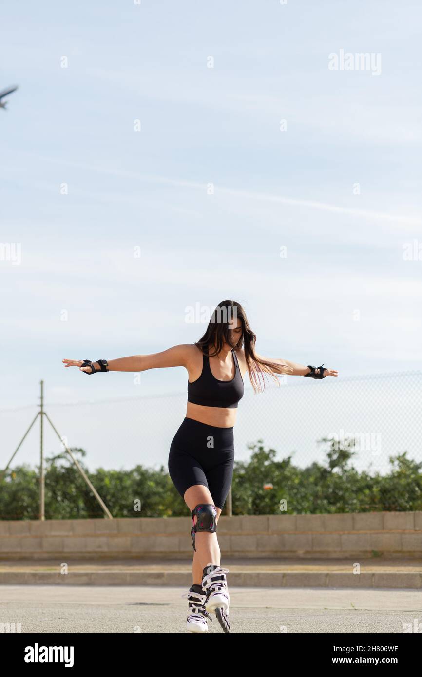 From below full body of active fit female outstretching arms while ...