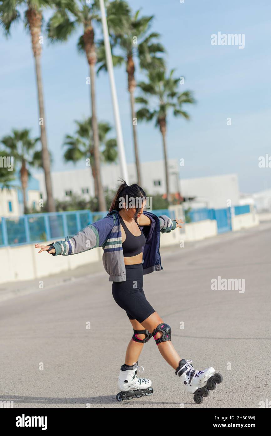 Full body side view of active fit female outstretching arms while ...