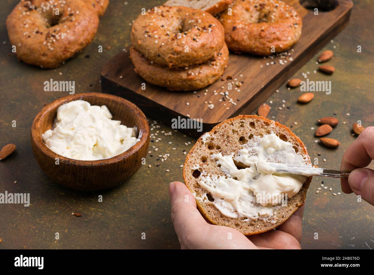 Crop anonymous male spreading tasty cream cheese on low carbohydrate ...