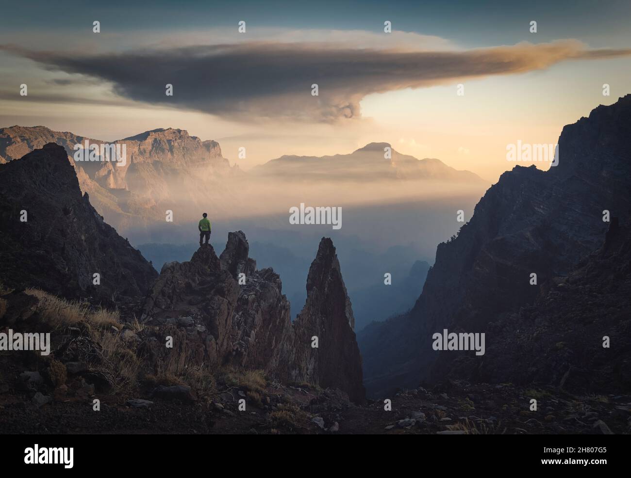 Breathtaking scenery of anonymous male traveler standing on rough rocky ...