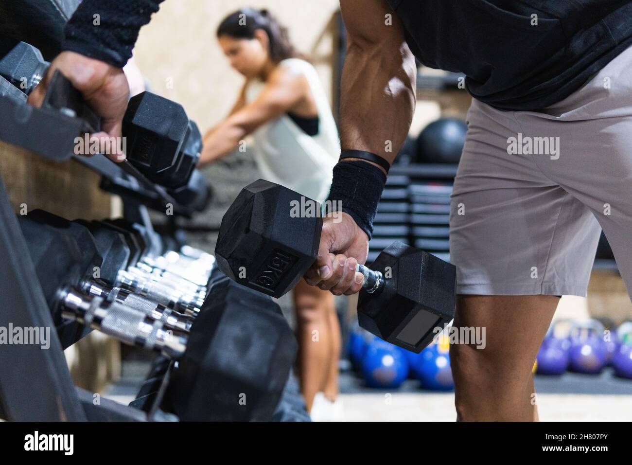 Crop unrecognizable muscular male bodybuilder taking heavy metal ...