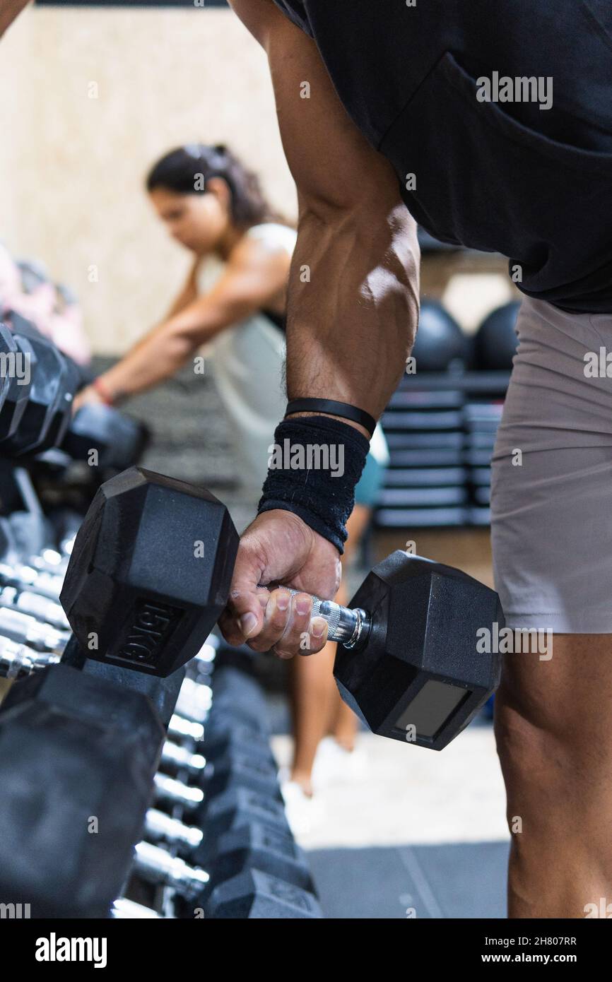 Crop unrecognizable muscular male bodybuilder taking heavy metal ...