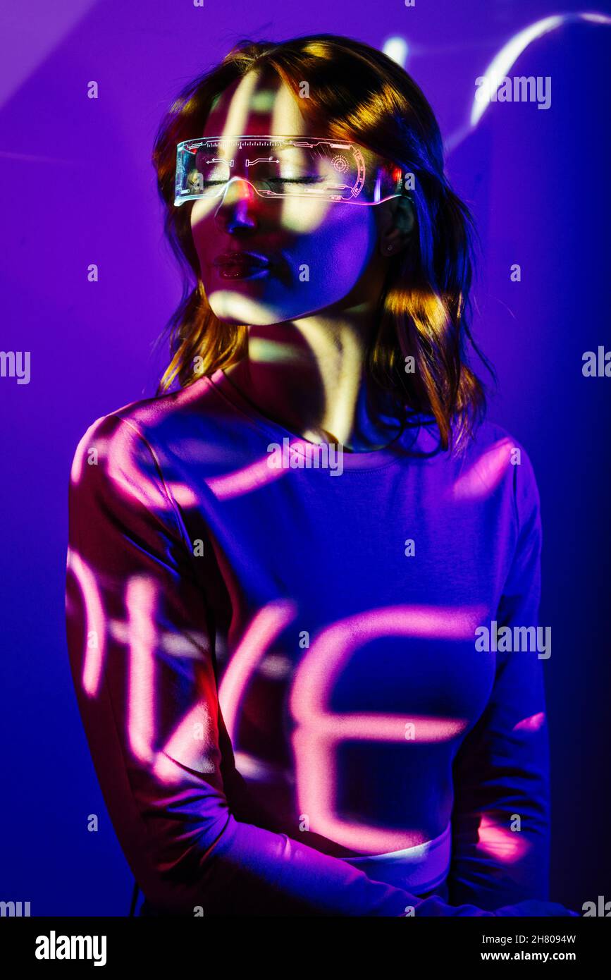 Young Woman with long hair in casual clothes standing in ultraviolet ...