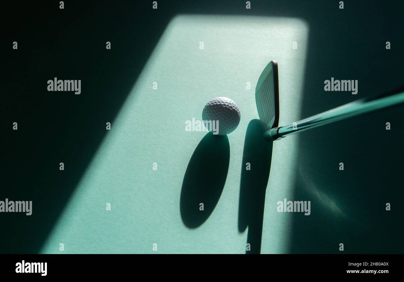 White golf ball and stick with natural lighting on mint background ...