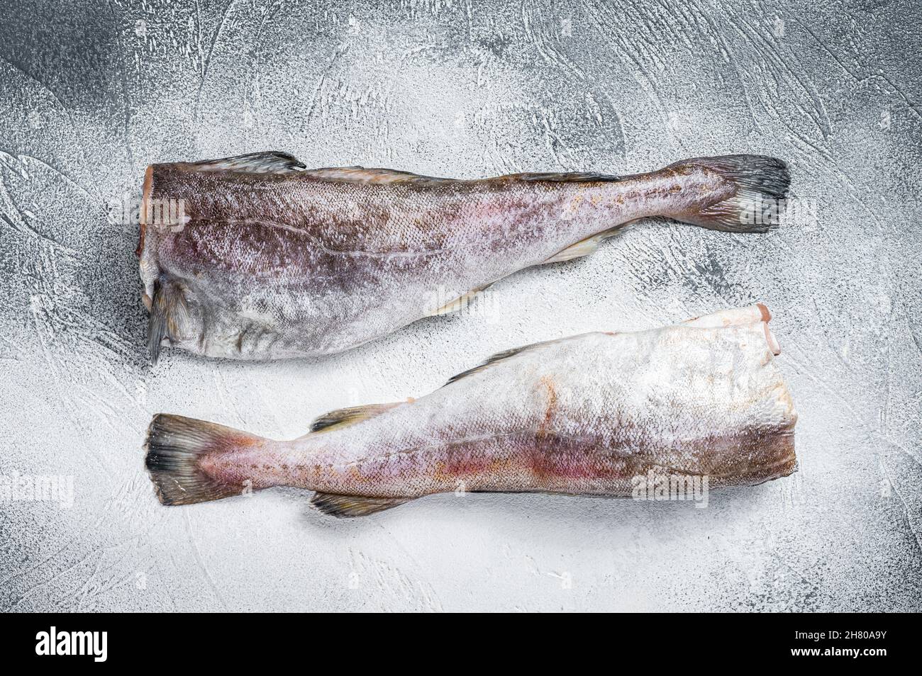 Raw cod whole fish on kitchen table. White background. Top view Stock ...