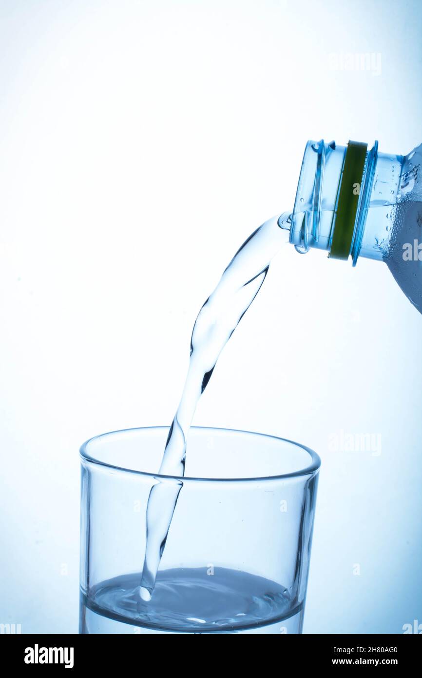 Pouring water from bottle into glass Stock Photo - Alamy